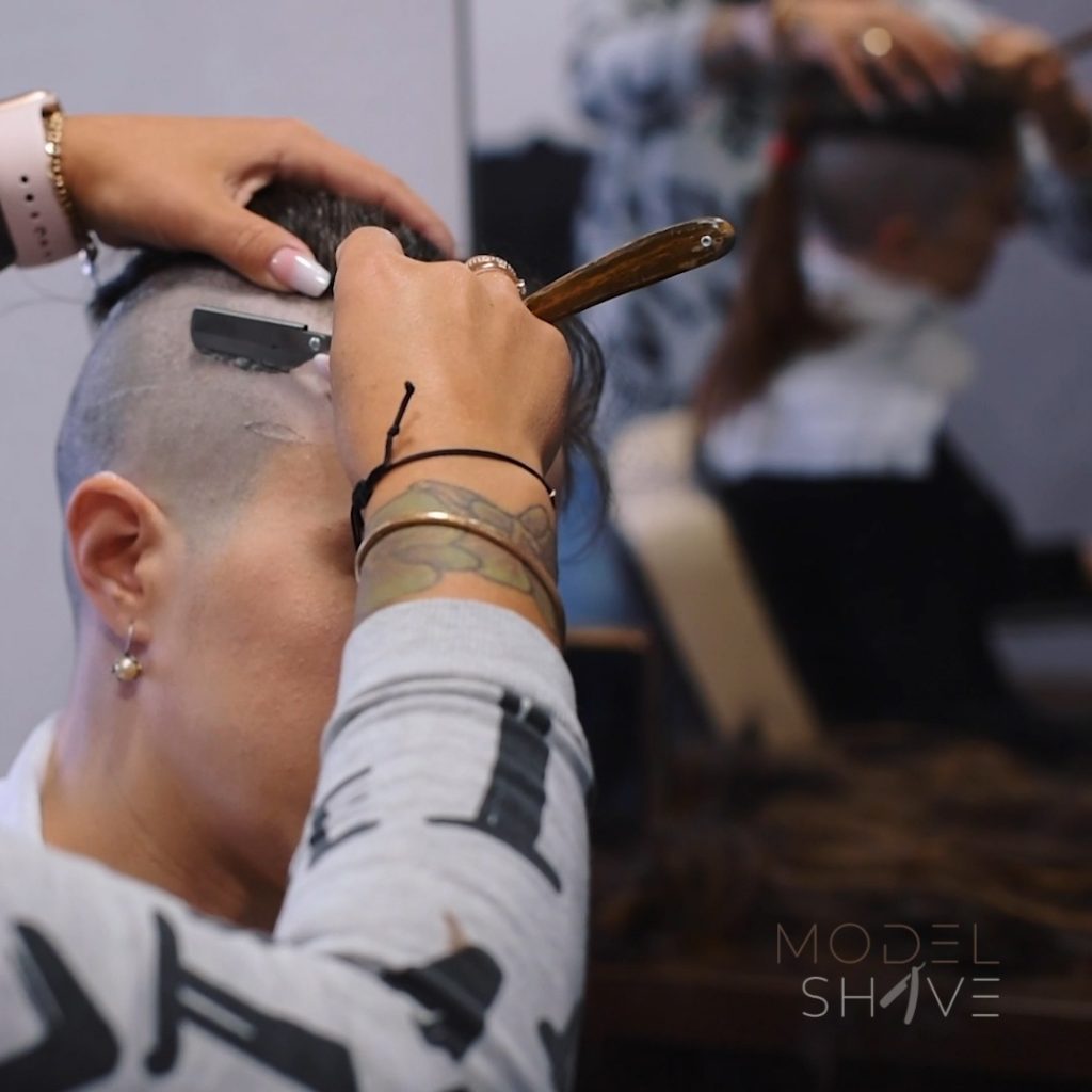Woman at the barbershop to make a smooth shiny headshave. - Model Shave