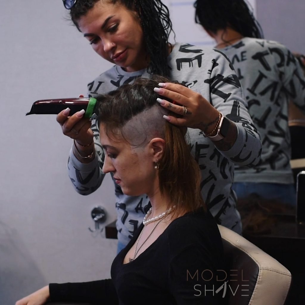 Woman at the barbershop to make a smooth shiny headshave. - Model Shave
